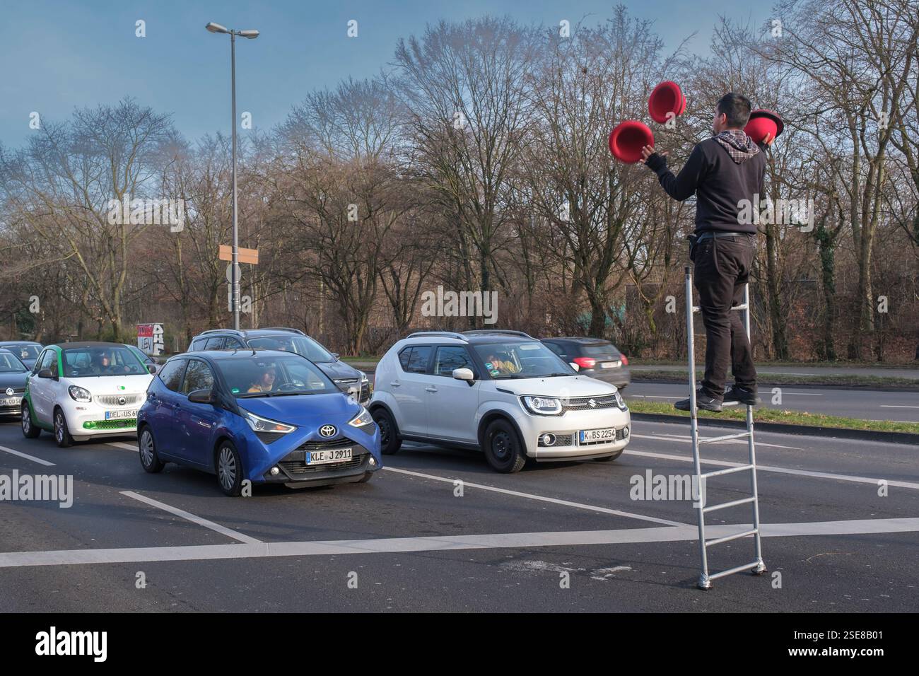 Juggler performs his tricks during a red traffic light pha Stock Photo ...