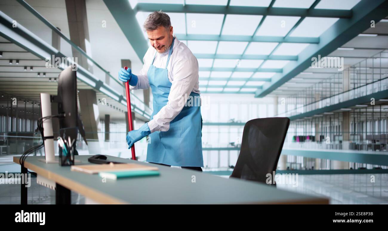 Male Janitor Cleaning Floor With Mop In Office Stock Photo - Alamy
