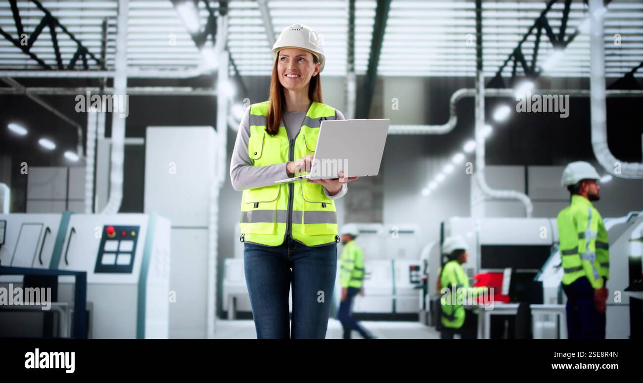 Female technician supervising automated production line at ...