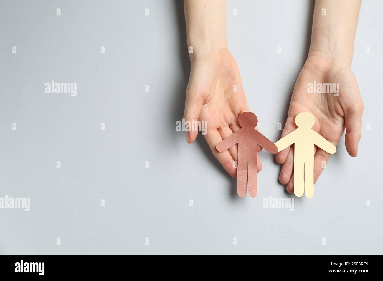 Stop racism. Woman holding human paper figures of different colors on ...