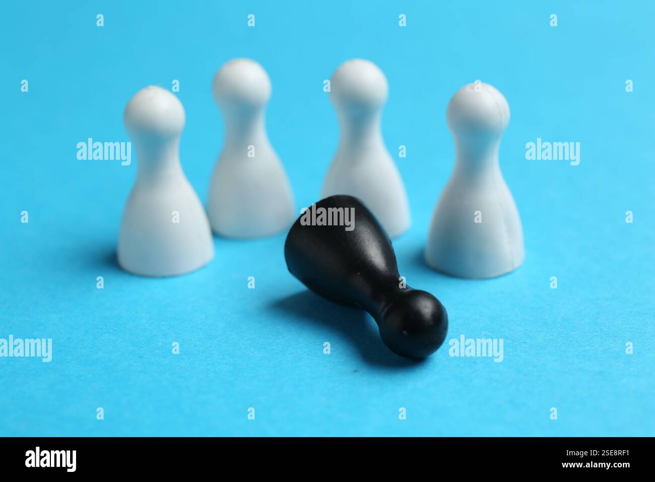 Stop racism. One black human figure among white ones on light blue ...