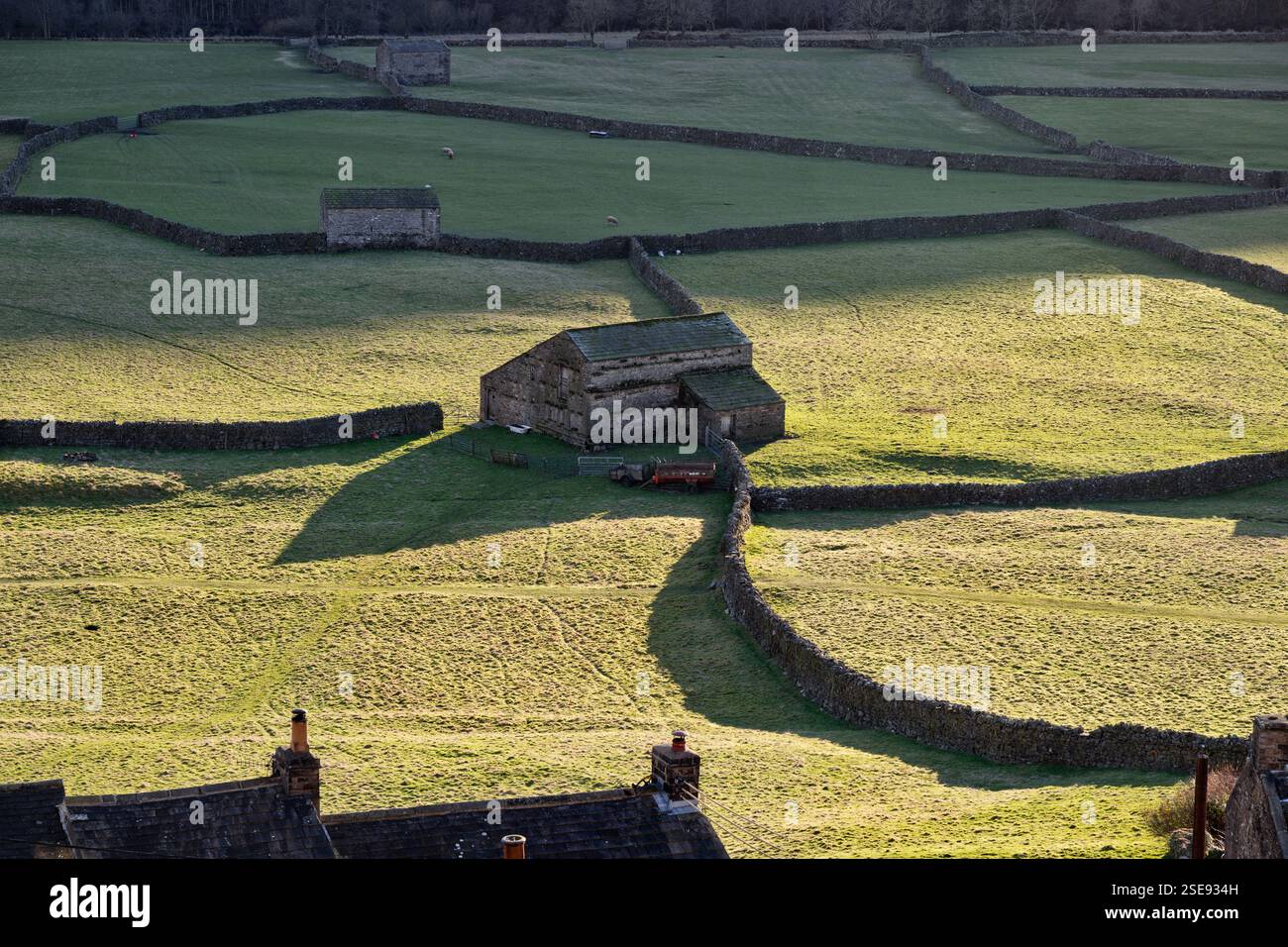 Traditional field barns and dry stone walls next to the village of ...