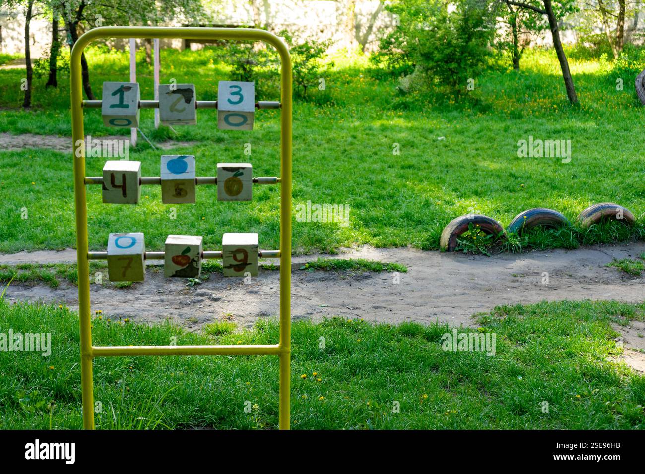 A vibrant playground setting features a yellow frame holding wooden ...