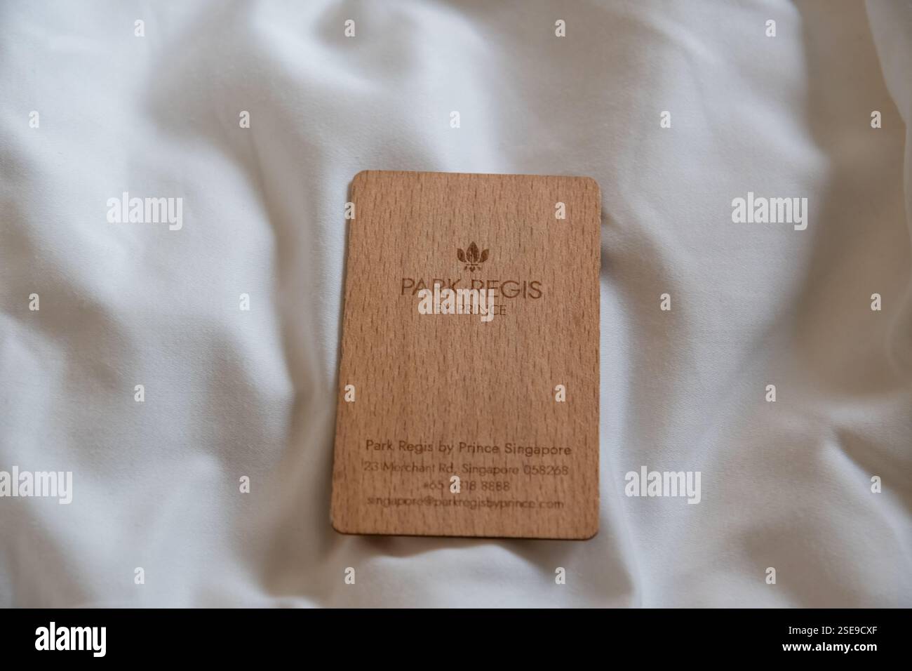A wooden Park Regis hotel key card featuring engraved branding and ...