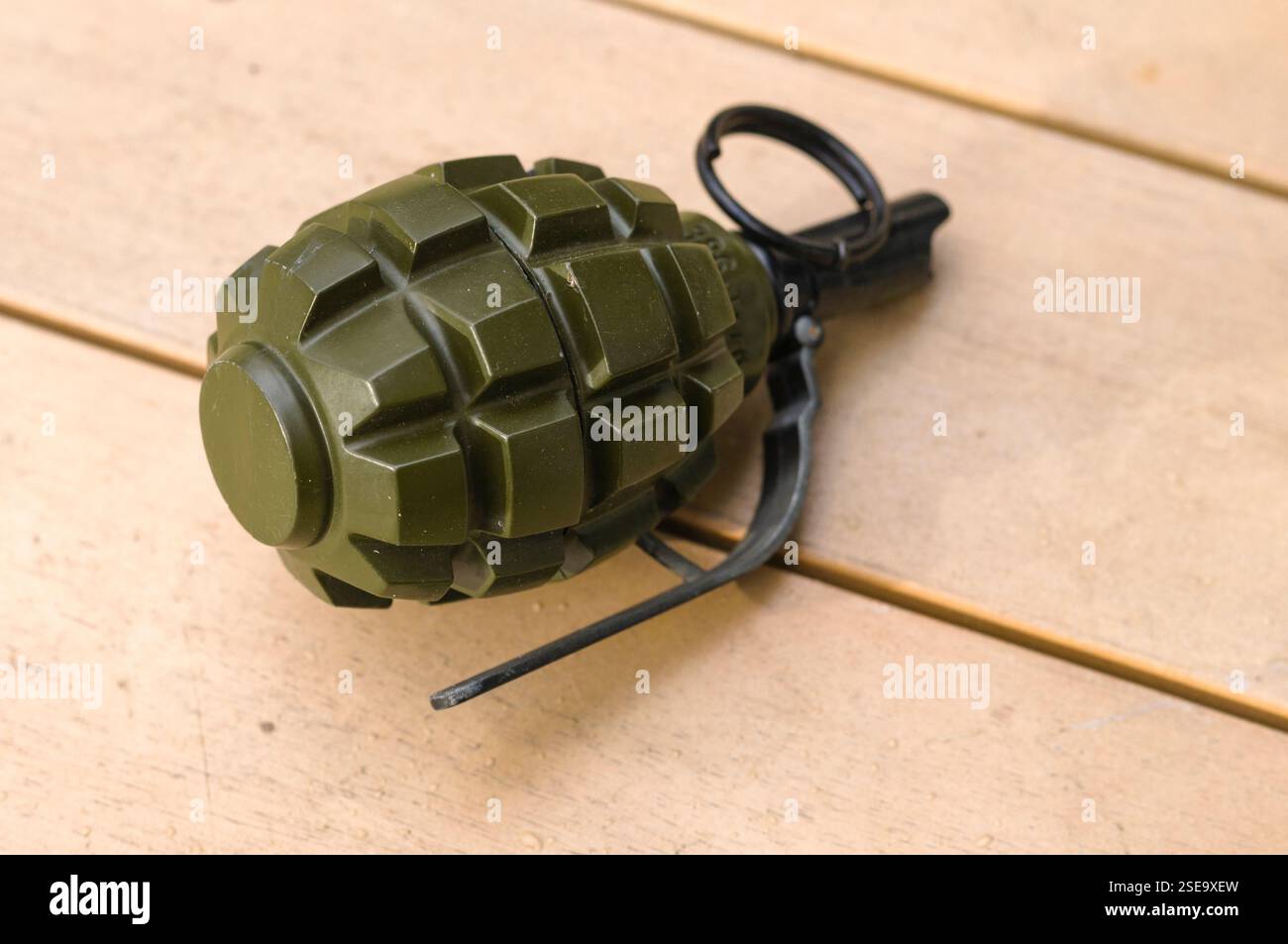 a hand grenade painted in green dropped on a table, no people Stock ...