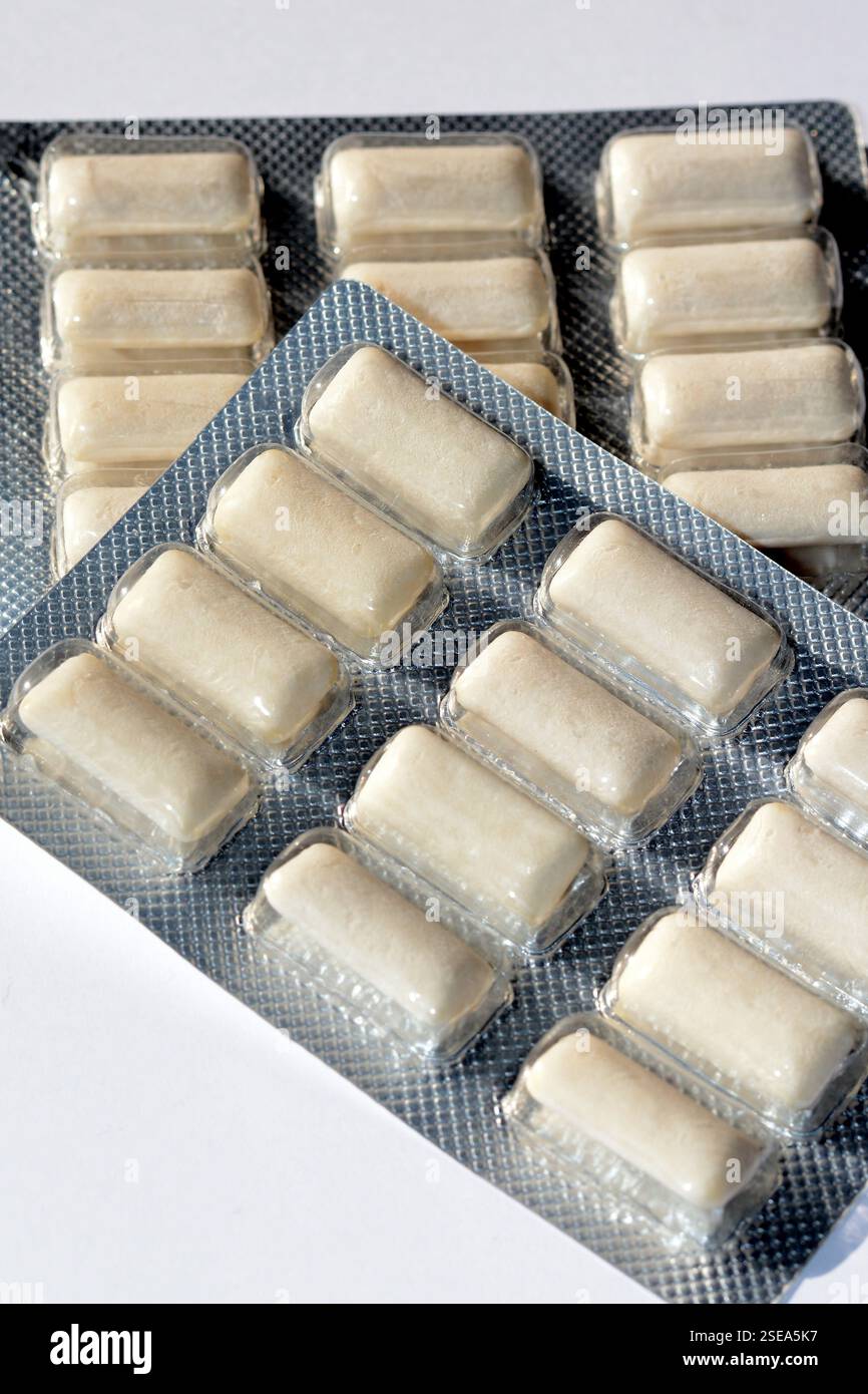 Two packs of medication tablets in a silver blister pack on a white ...