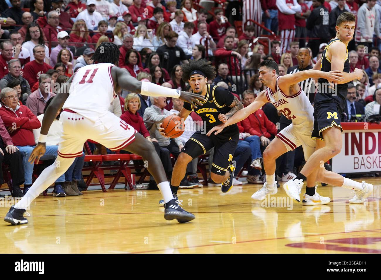 Michigan's Tre Donaldson, center, drives to the basket as Indiana's ...