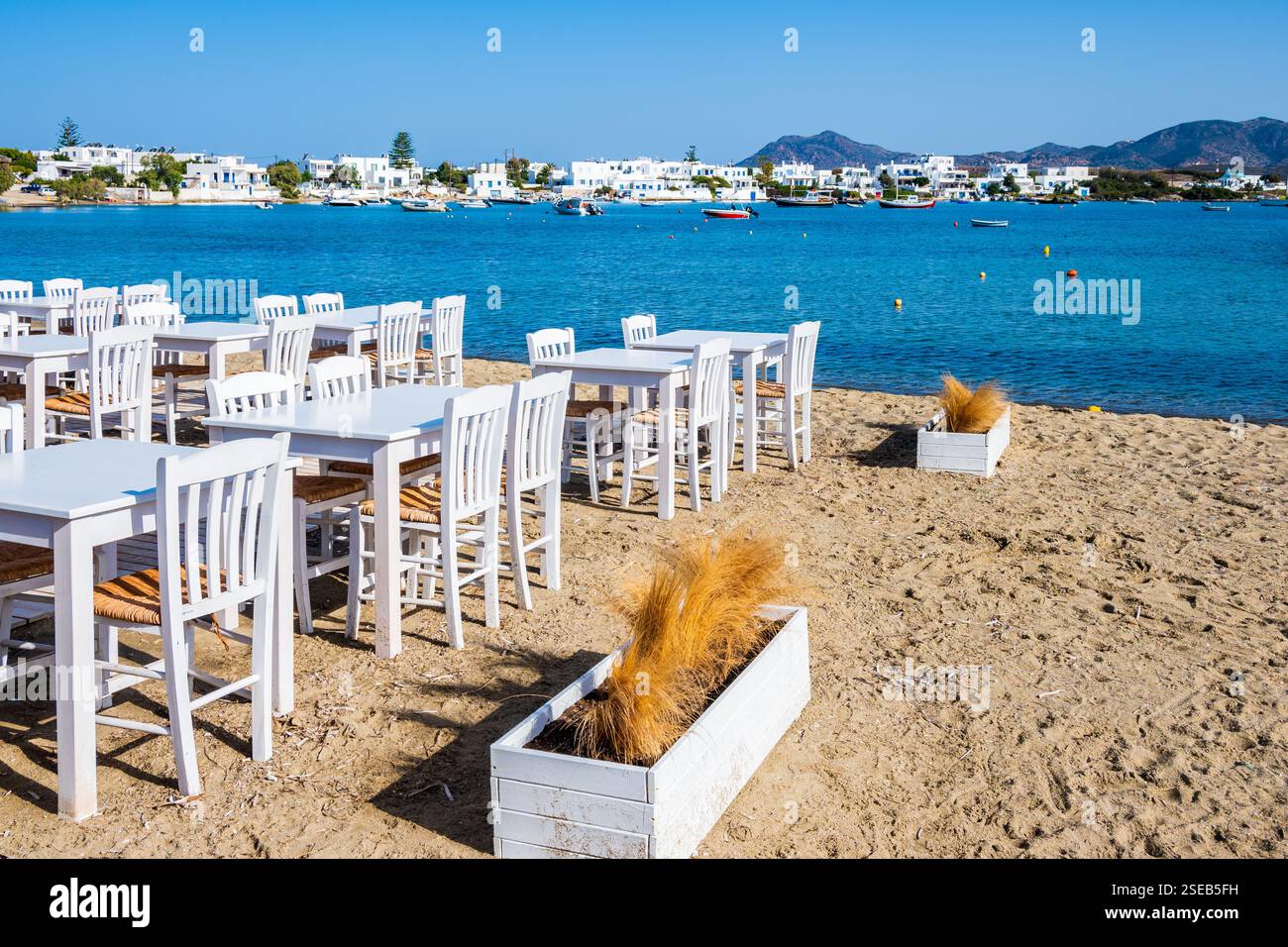 Taverrna chairs and tables on beach in Pollonia port, Milos island ...