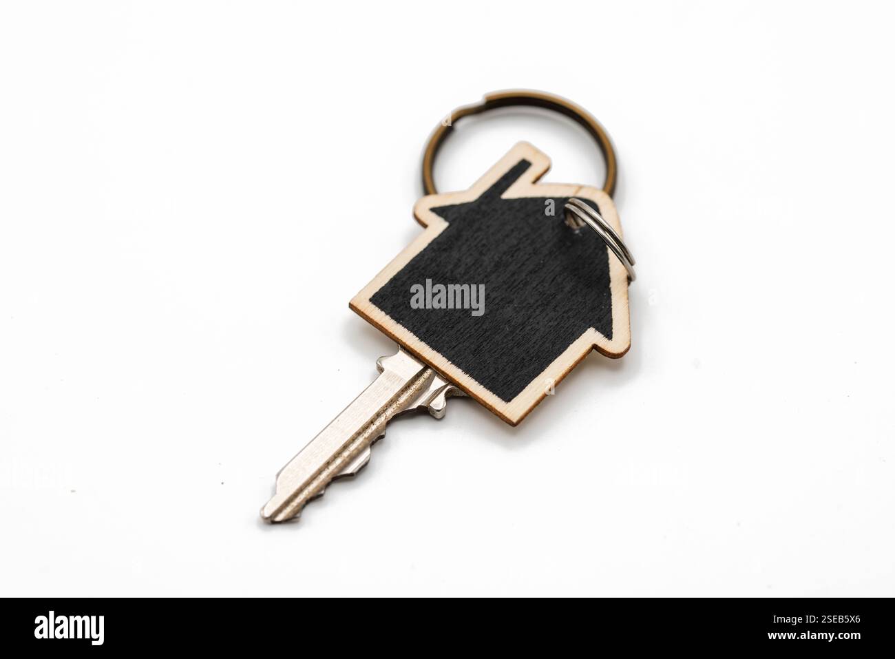 Llavero de madera con forma de casa con una llave, aislado en blanco ...