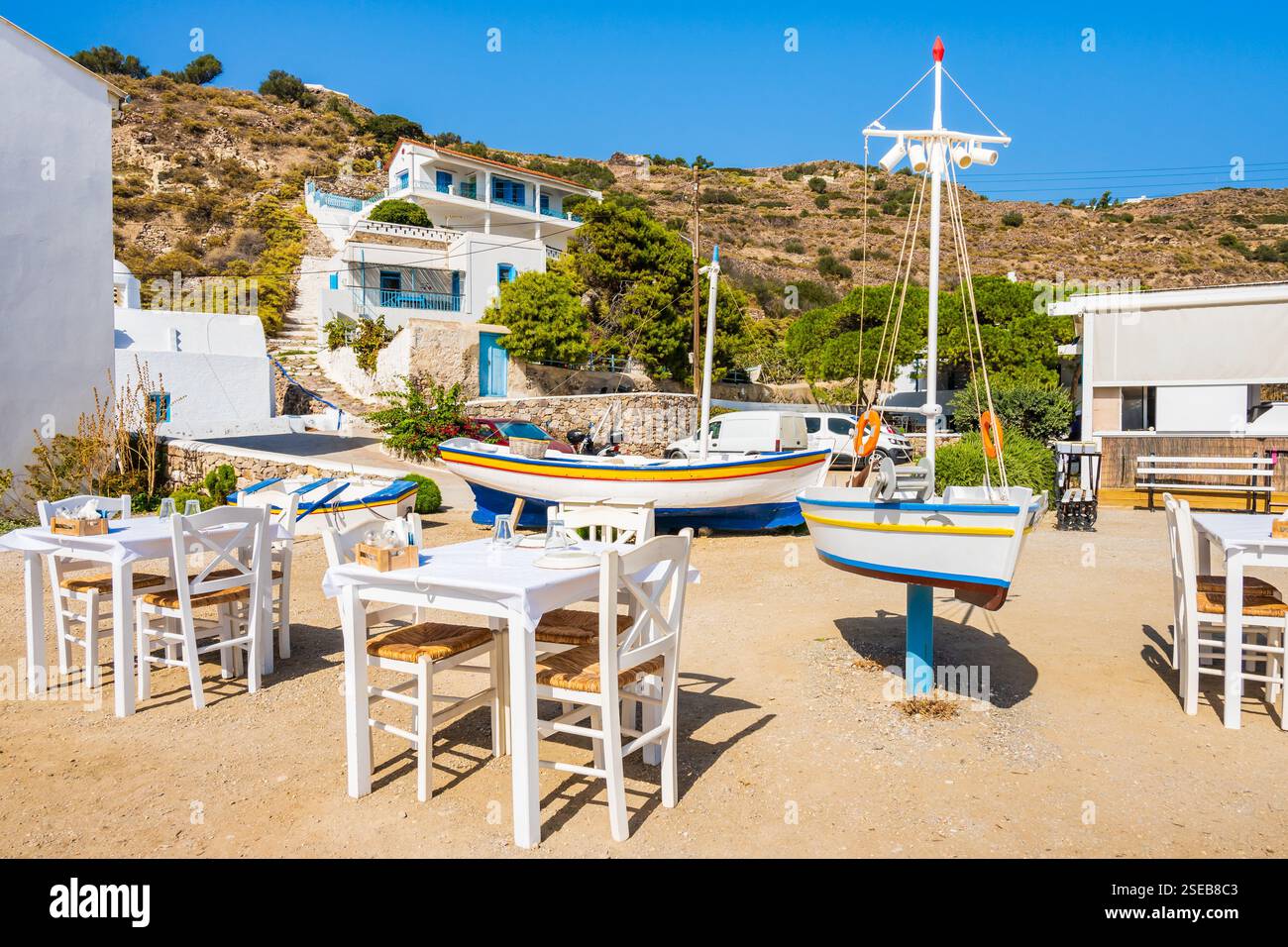 Taverna tables with chairs on small square in Klima village, Milos ...