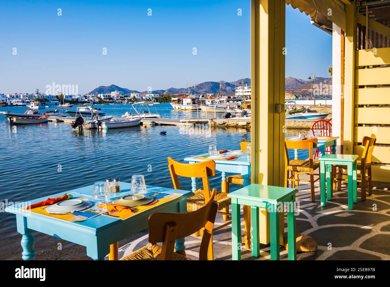 Tables and chairs in typical Greek taverna restaurant in Pollonia port ...