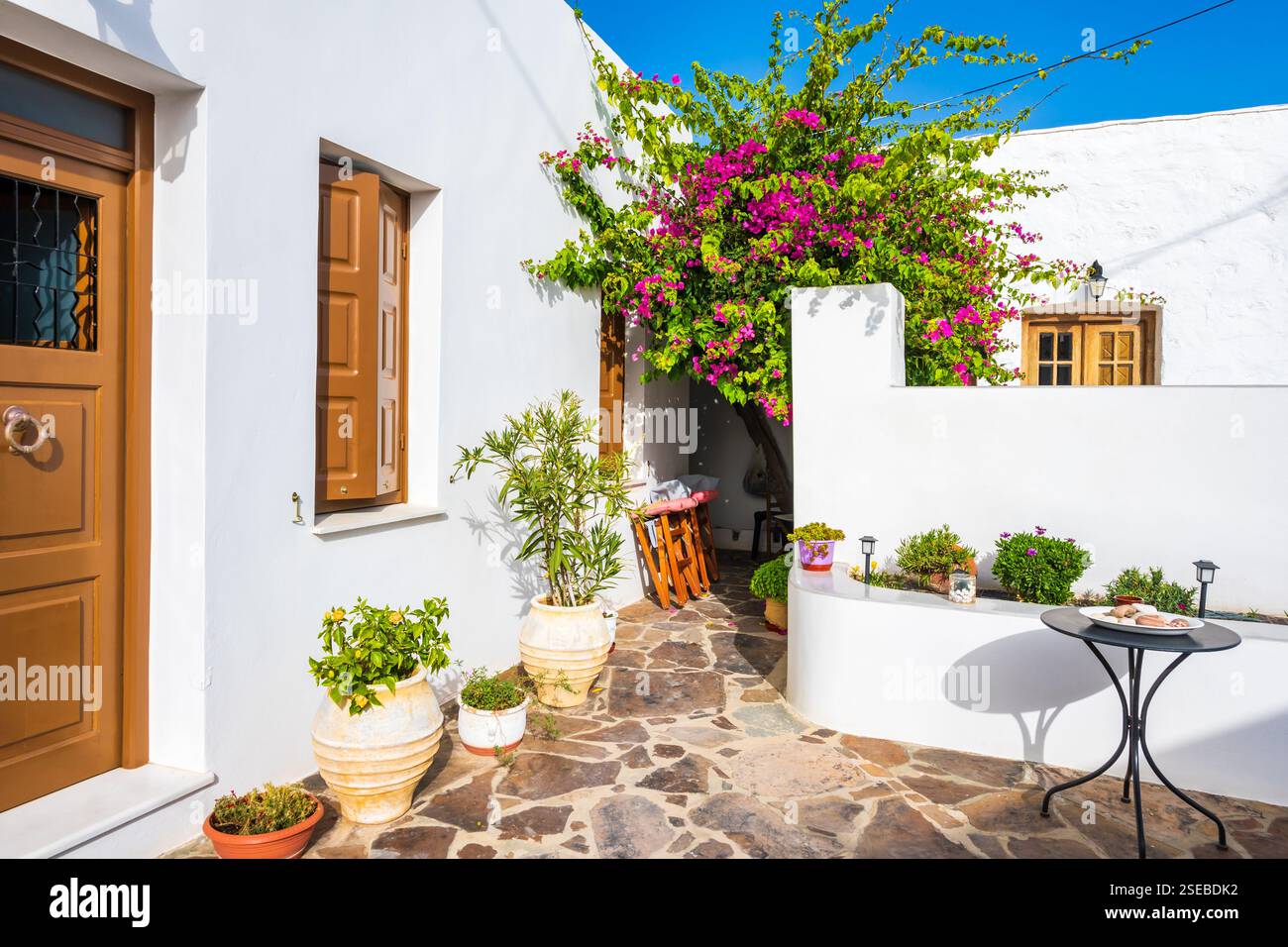Typical Greek white house and terrace with flowers in Plaka village ...