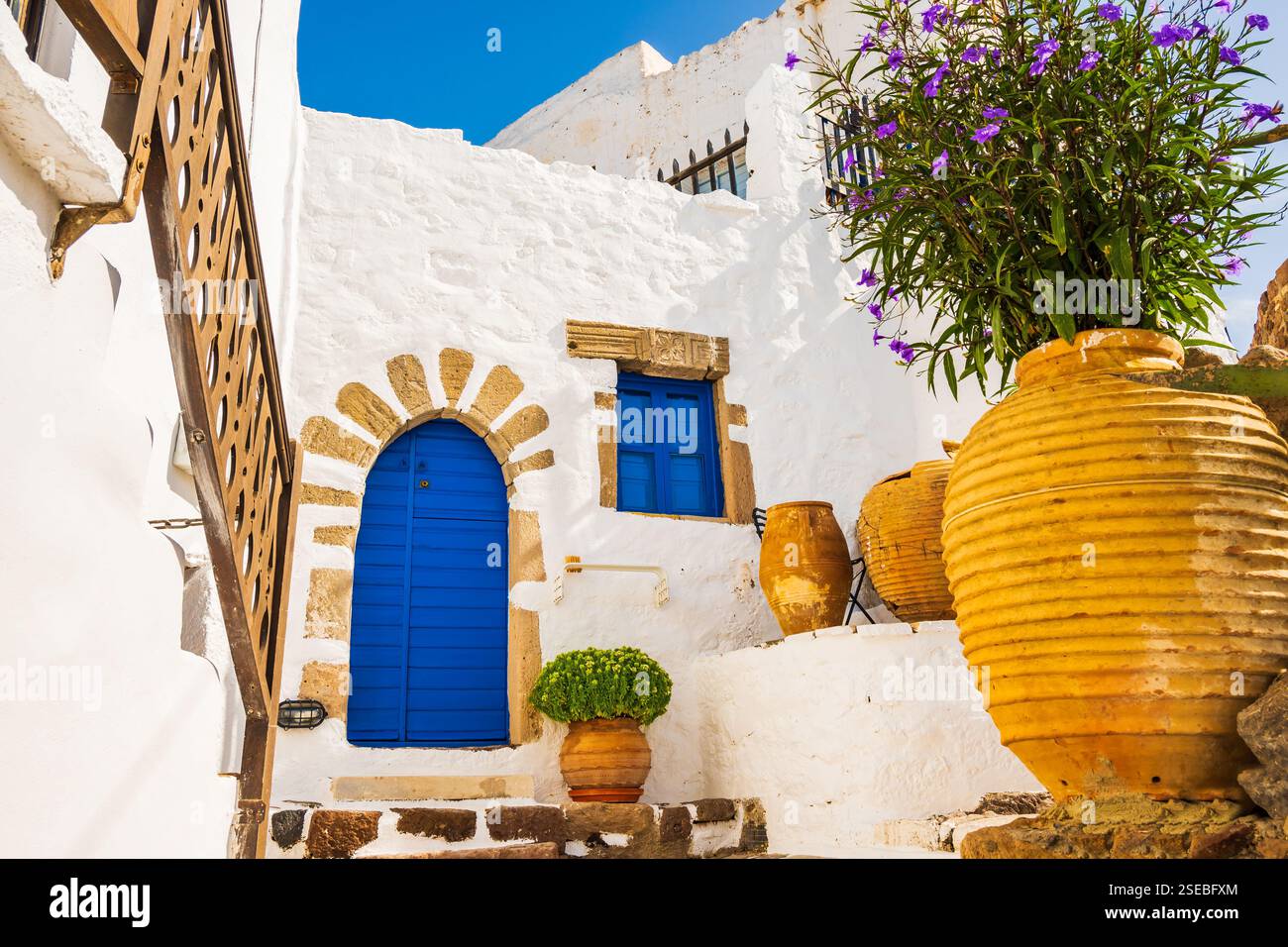 Typical white Greek house with blue door and window in Plaka village ...