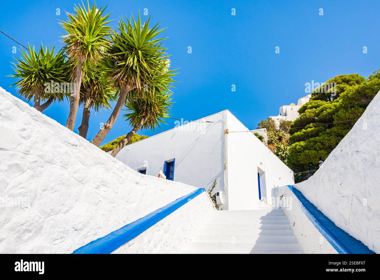 White steps to traditional Greek restaurant with tropical garden in ...