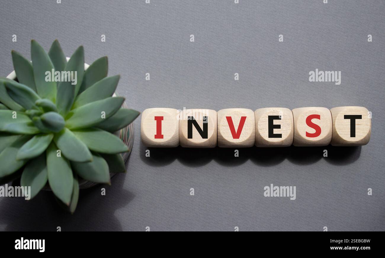 Invest symbol. Wooden blocks with word Invest. Beautiful grey ...
