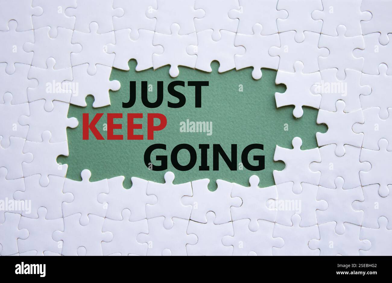 Just keep going symbol. White puzzle with words Just keep going. Beautiful grey green background ...