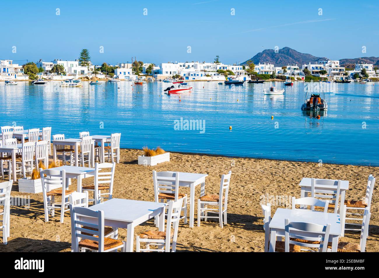 Taverrna chairs and tables on beach in Pollonia port, Milos island ...