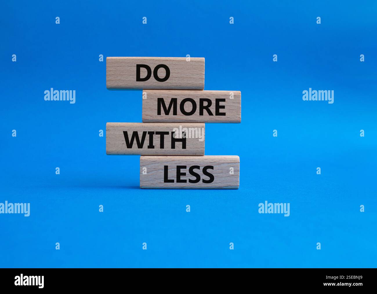 Do more with less symbol. Concept words Do more with less on wooden blocks. Beautiful blue ...