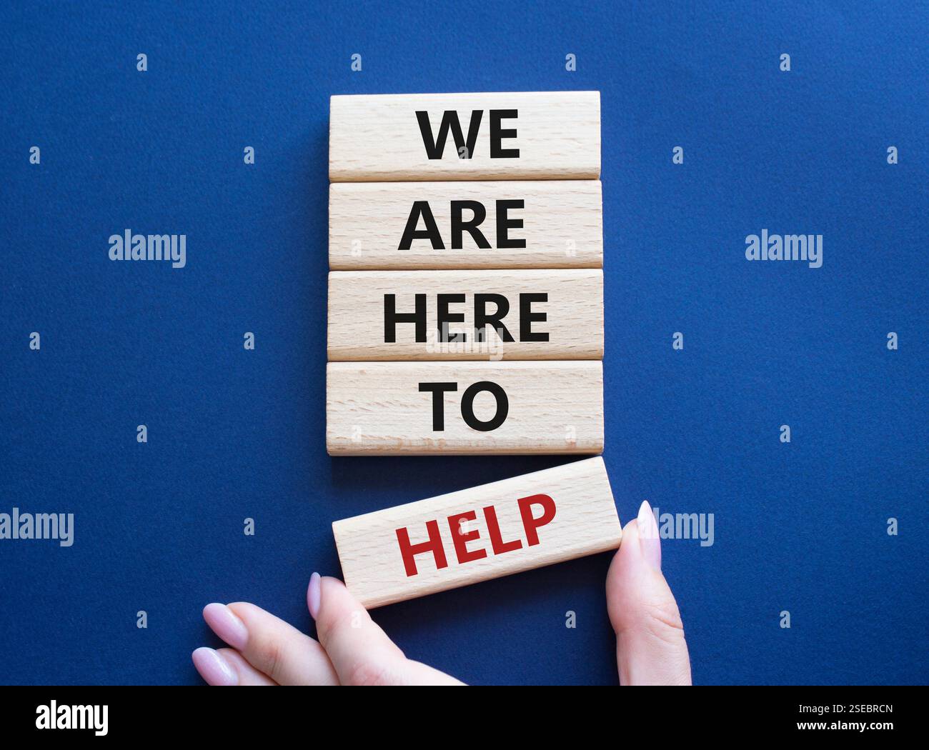 We are here to help symbol. Concept words we are here to help on wooden ...