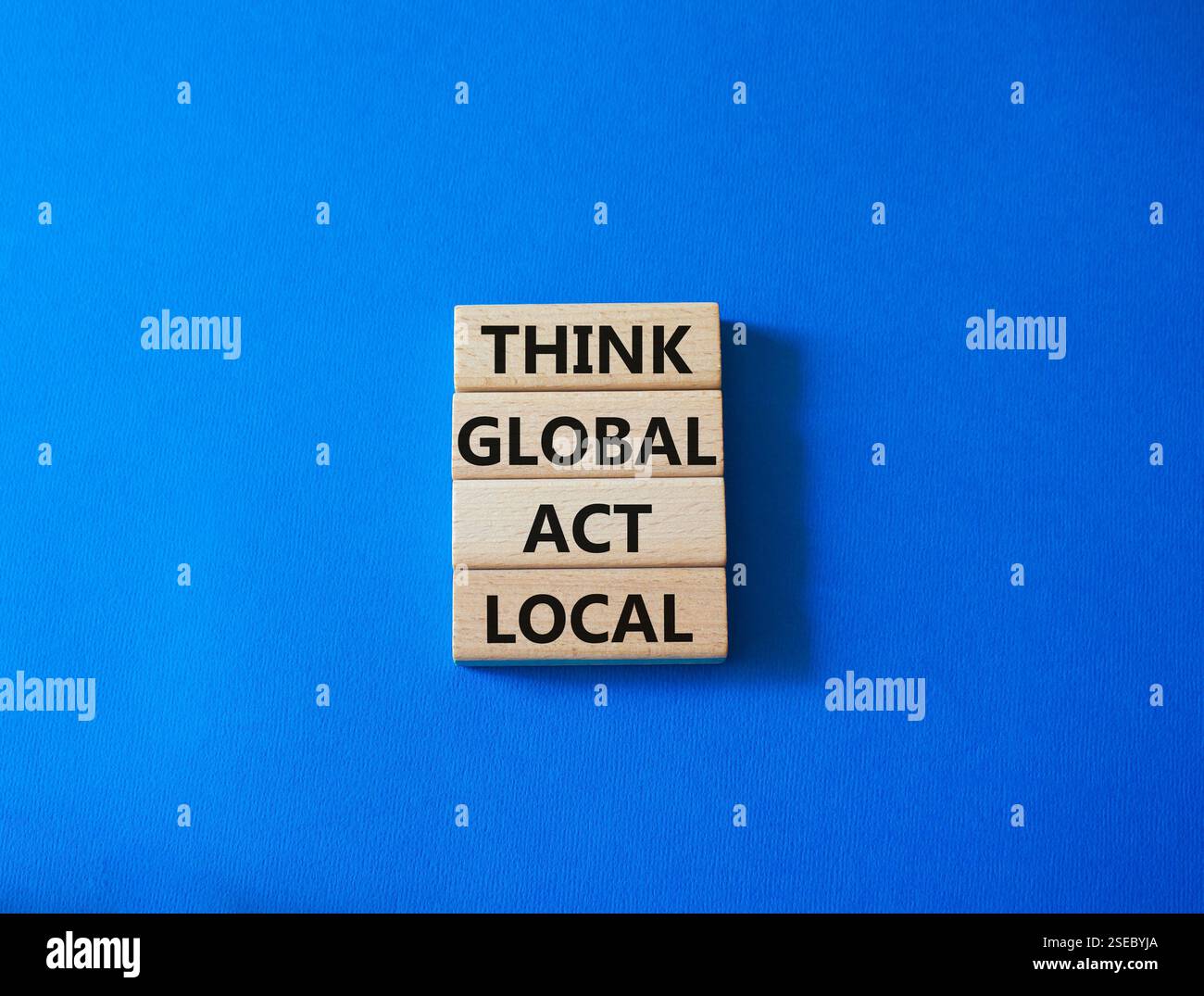 Think global act local symbol. Wooden blocks with words Think global act local . Beautiful blue ...