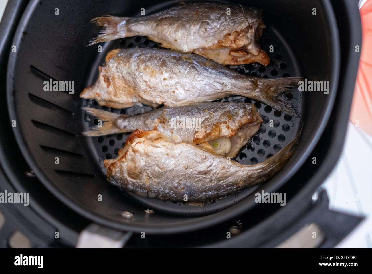 Frying medium sized fish in airfryer close up Stock Photo - Alamy