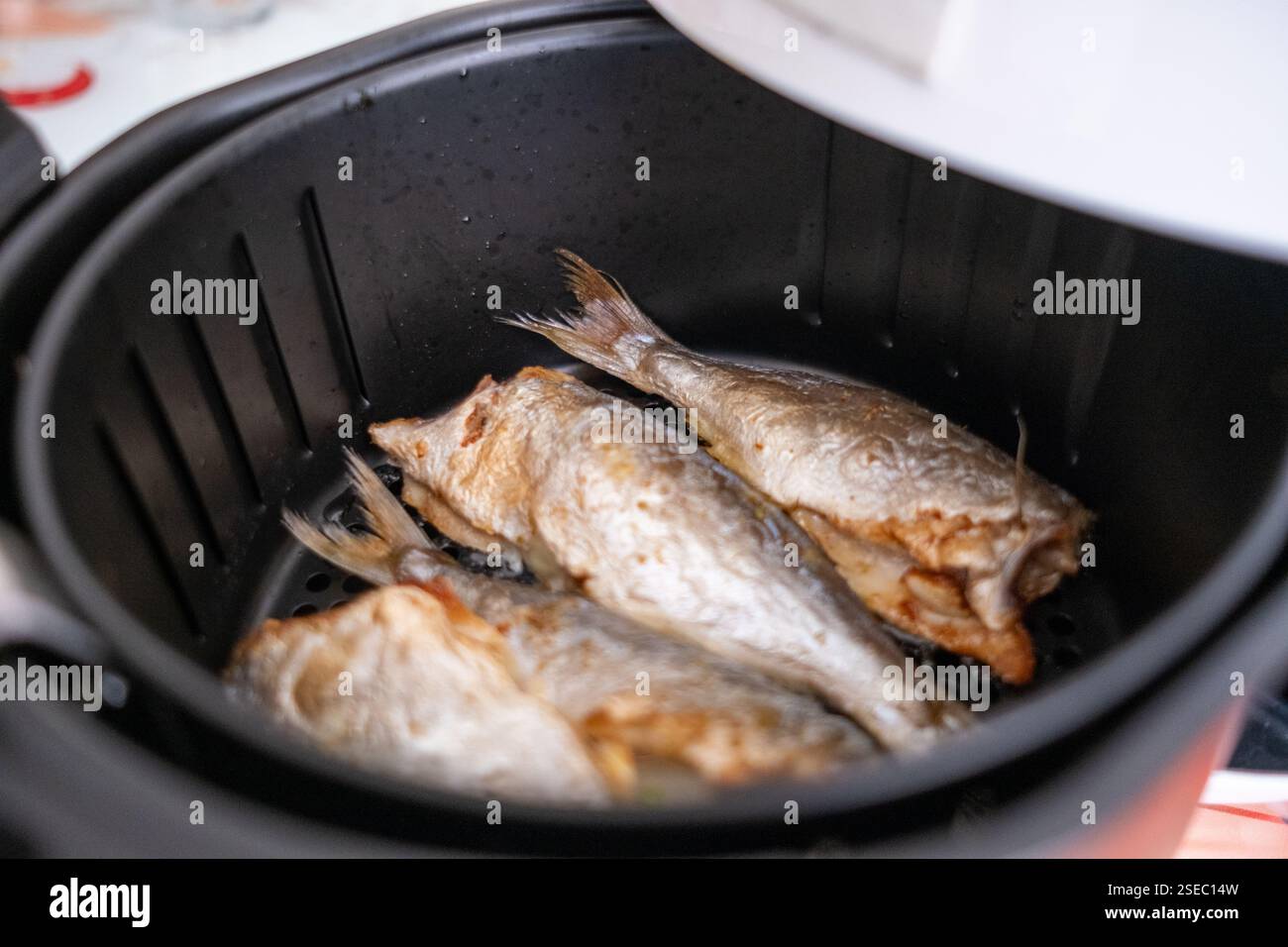 Frying medium sized fish in airfryer close up Stock Photo - Alamy