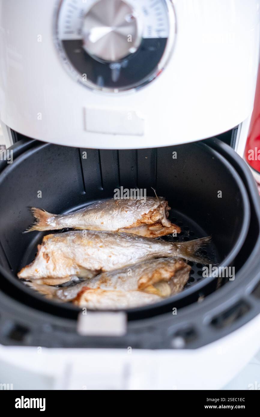 Frying medium sized fish in airfryer close up Stock Photo - Alamy