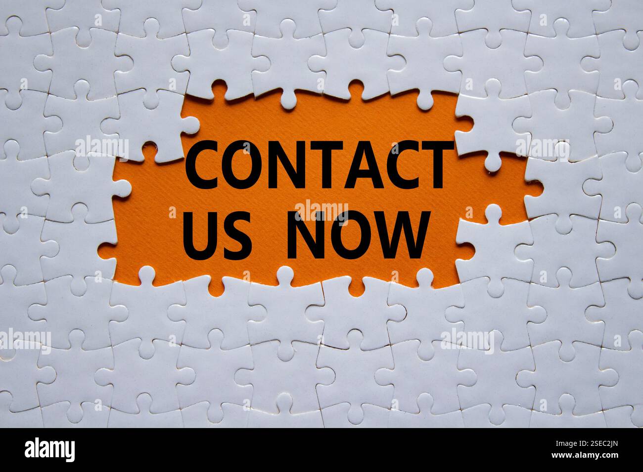 Contact us now symbol. White puzzle with words Contact us now ...