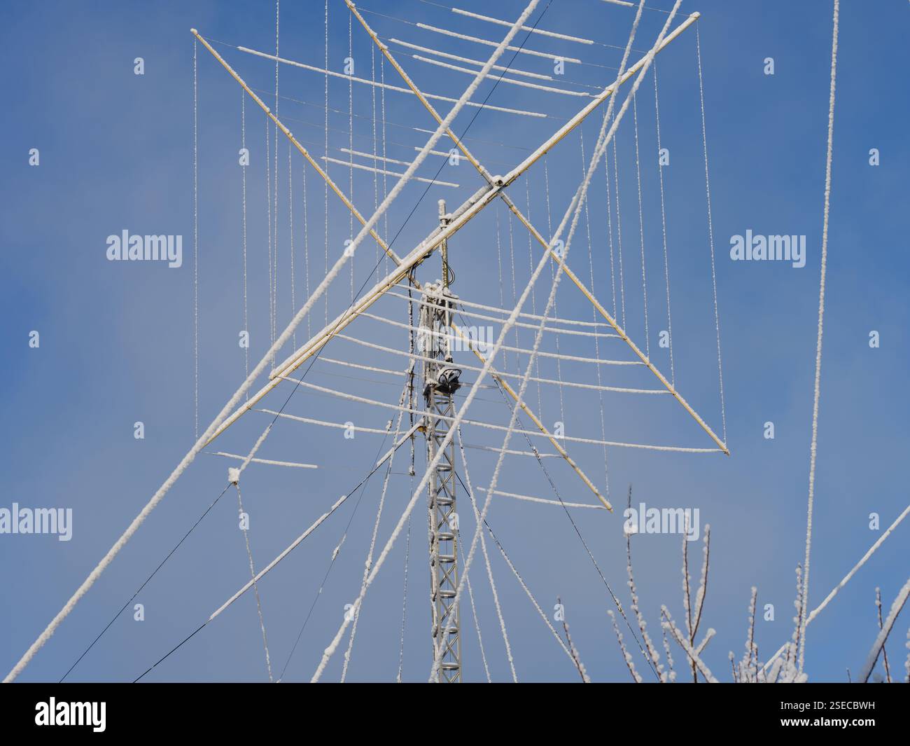 Ham radio antenna with stay ropes covered in snow against a blue winter sky Stock Photo - Alamy