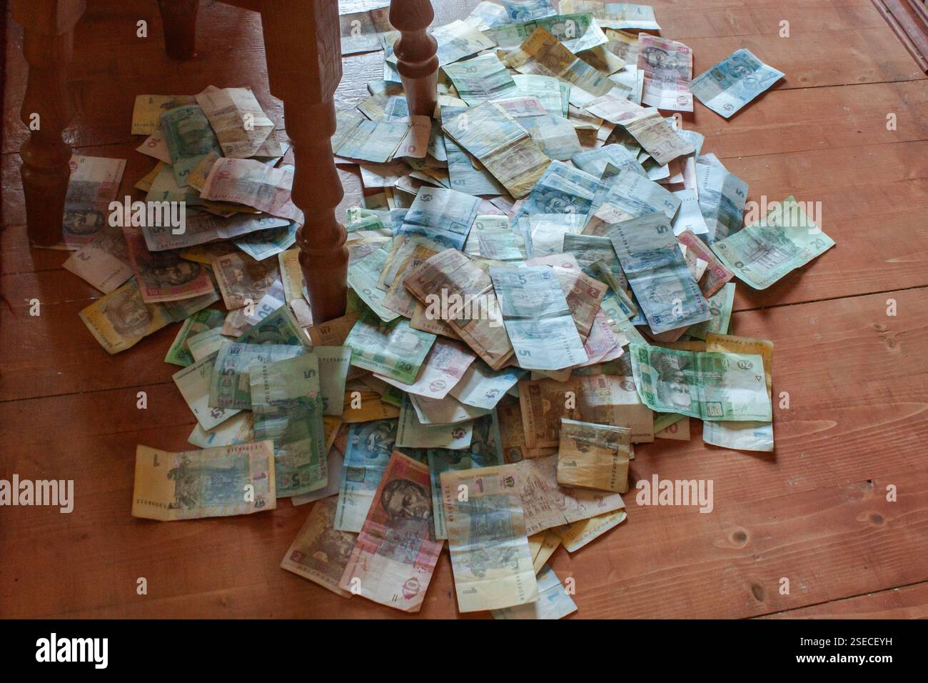 old paper bills are thrown in a pile on the floor near the table leg ...