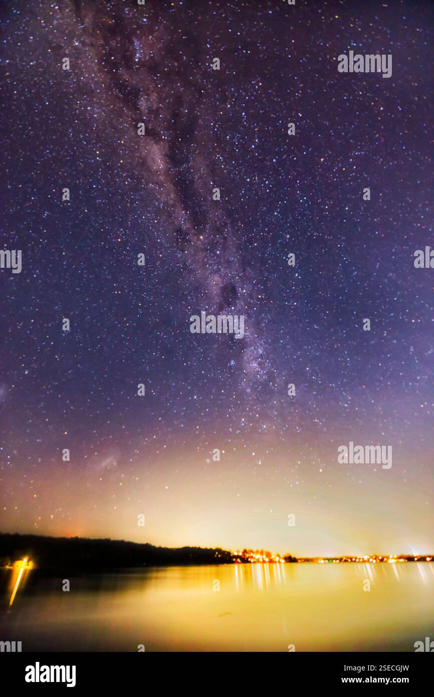 Bright Milky Way night sky constellation over still waters of Lake ...