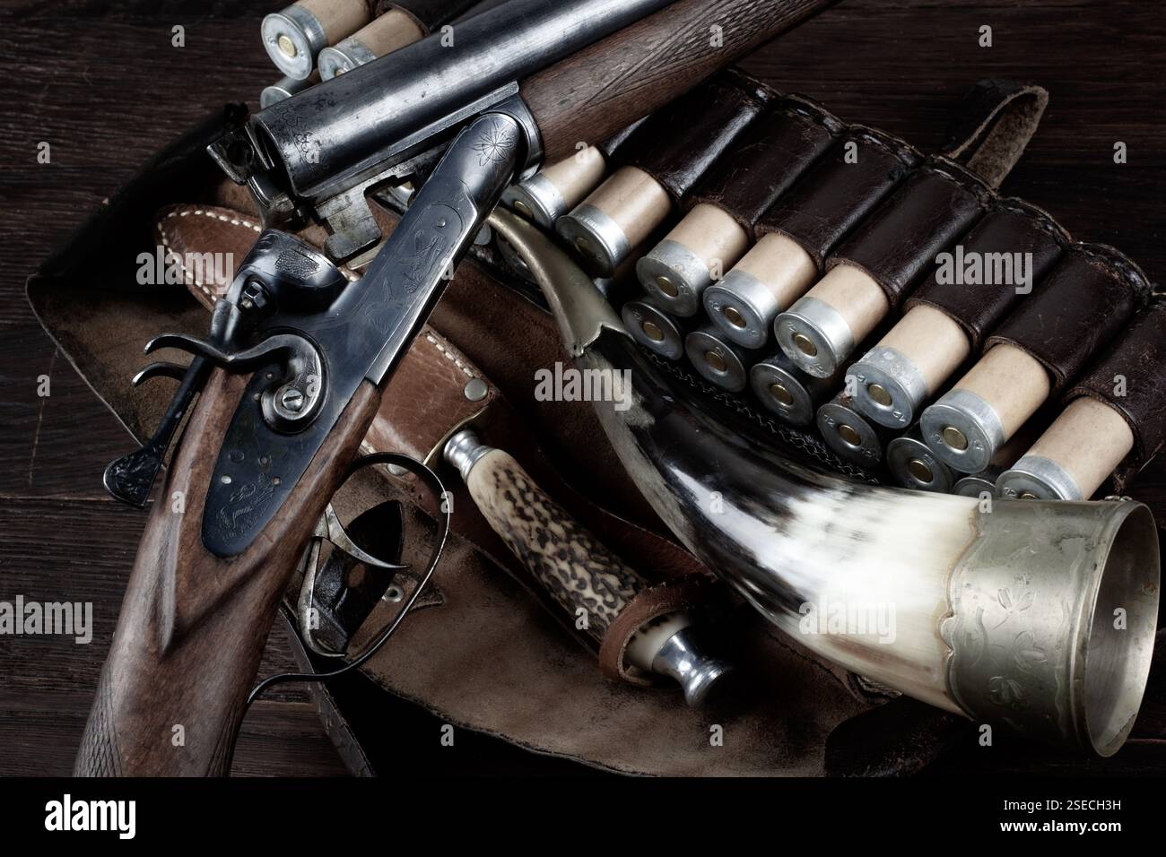double barreled side shotgun with cartridges in bandolier on wooden ...