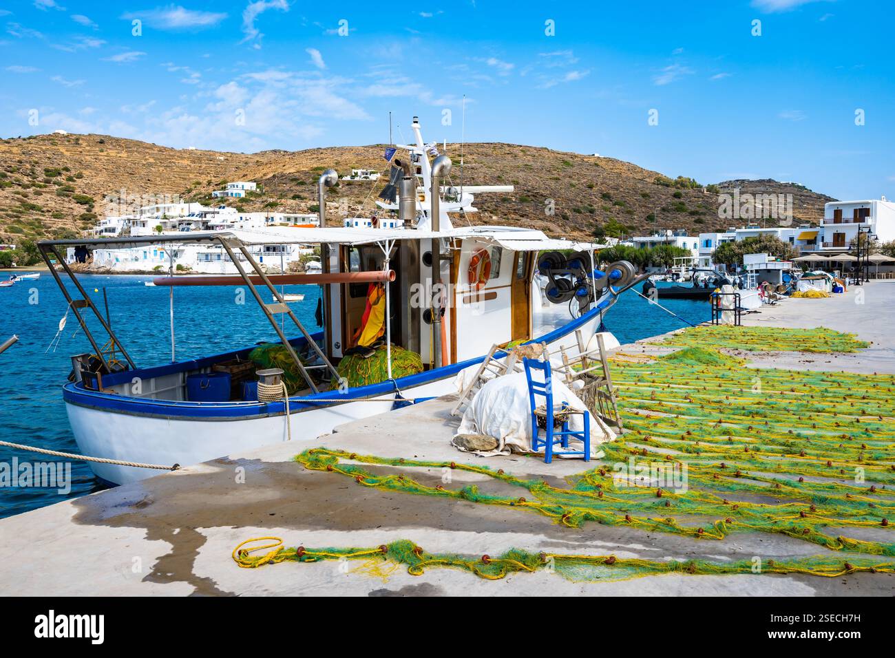 Boat with fishing nets in Faros port and mountains in background ...