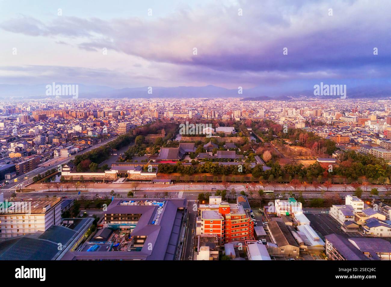 Aerial cloudy sunrise over greater Kyoto city around historic district ...