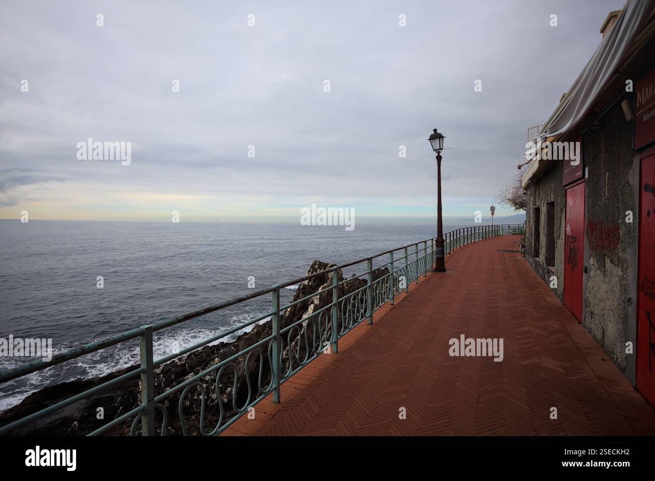 Promenade with street lights on a cliff with trees and buildings by its ...