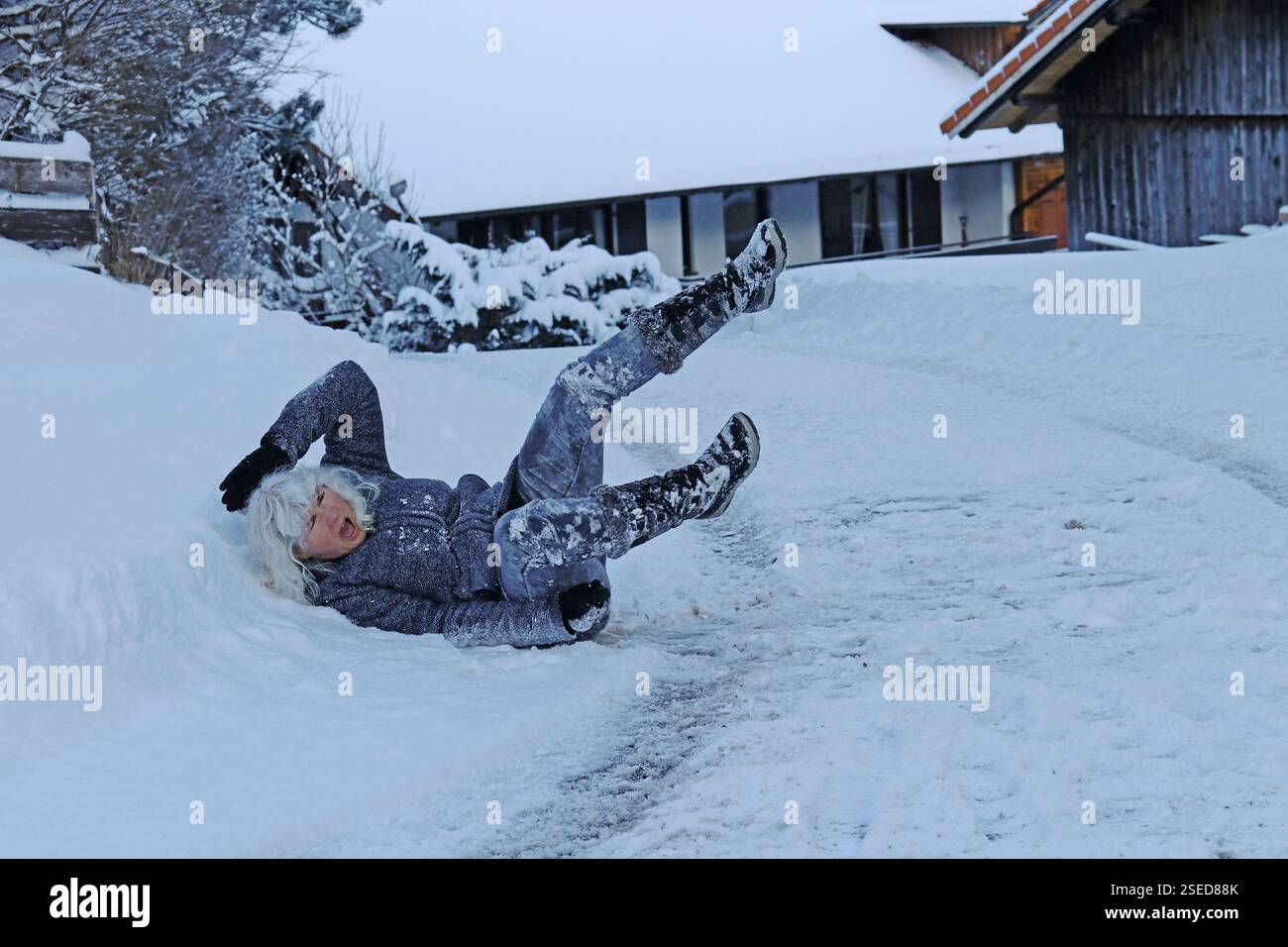 Risk of slipping on a slippery road in winter. A woman slipped and fell ...