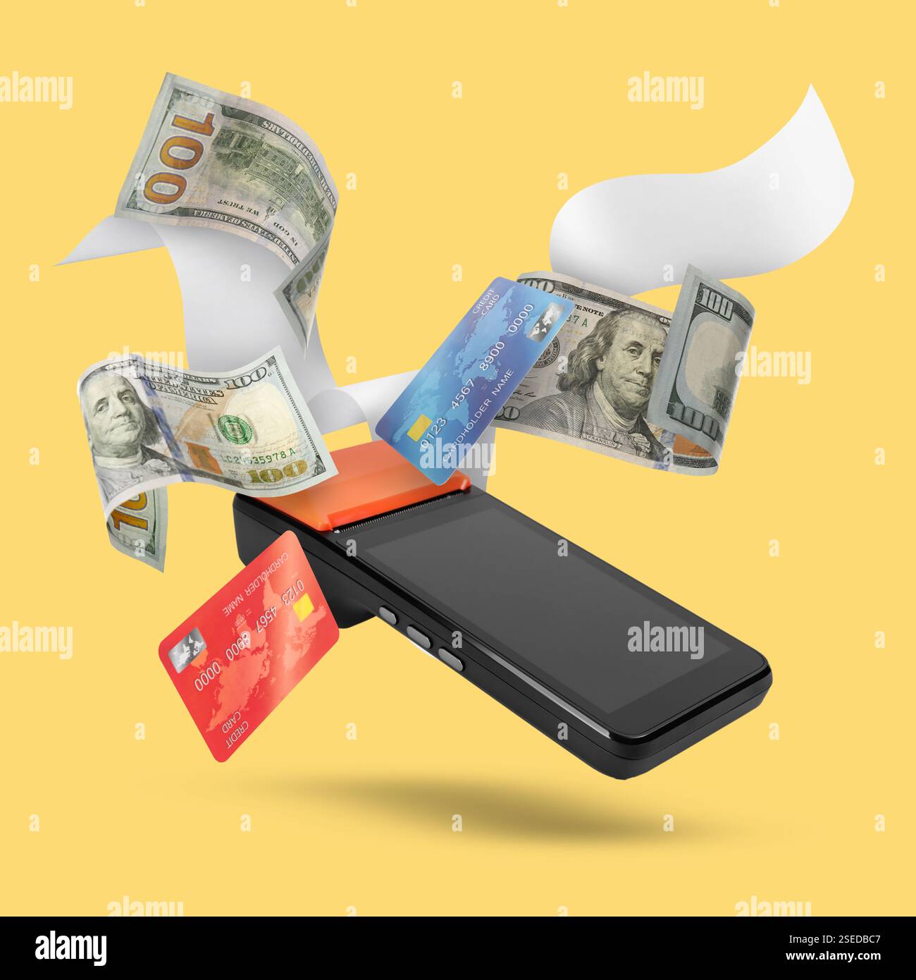 Payment terminal, bank cards, dollars and receipt in air on yellow ...