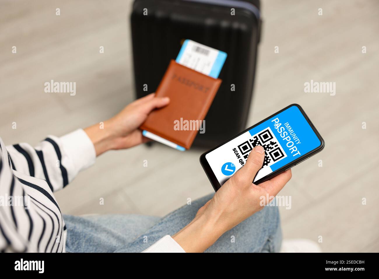 Tourist with passport, flight ticket and mobile phone indoors, above ...