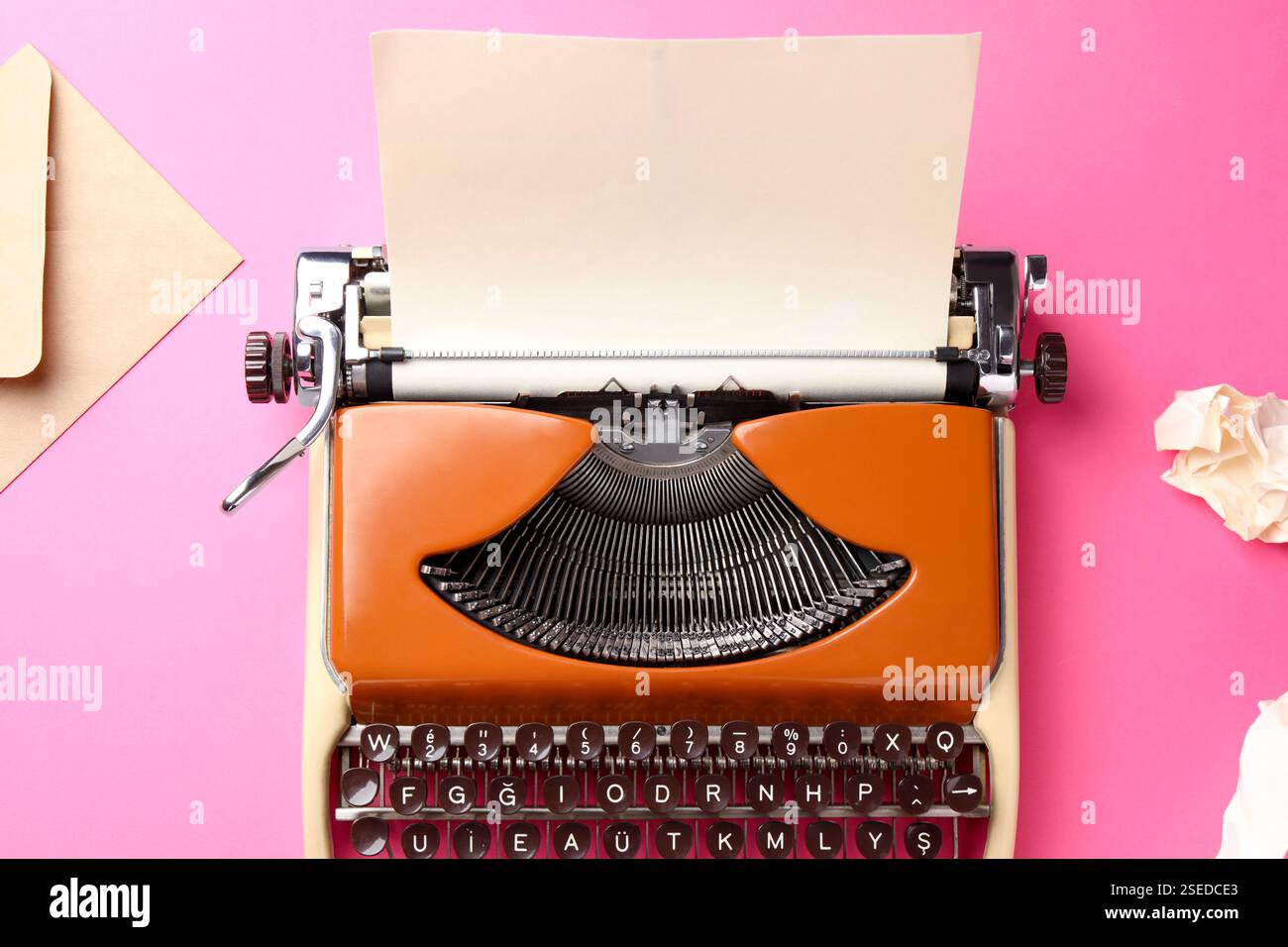 Vintage typewriter with sheet of paper and envelope on pink background ...