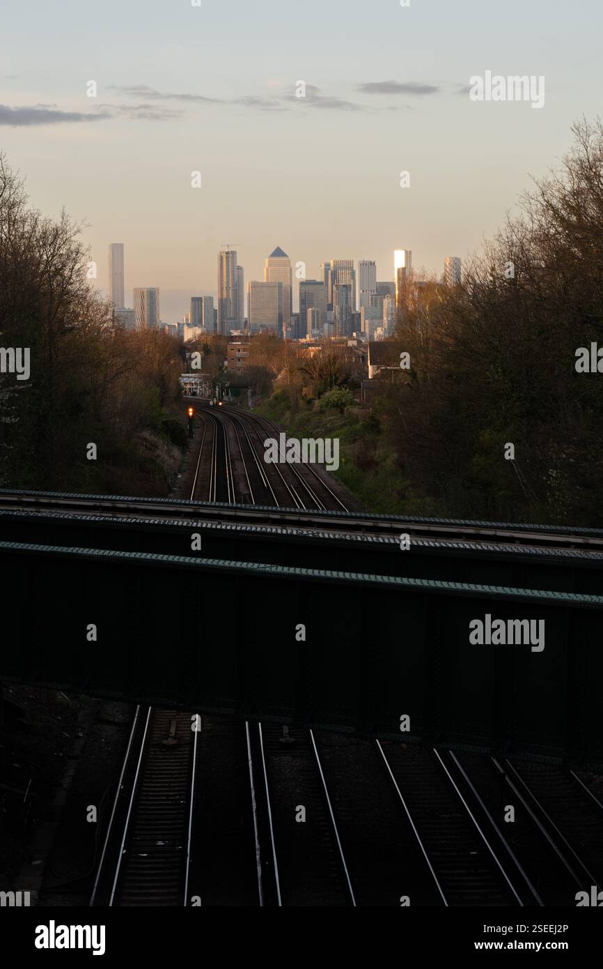 Train tracks under a bridge, Canary Wharf, London, UK. City skyline ...