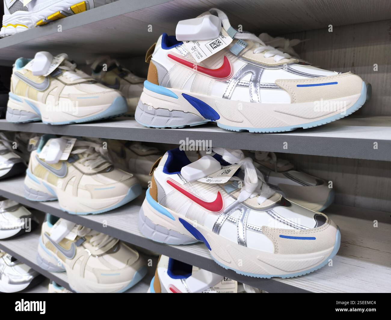 Colorful sports sneakers display with security tags on store shelves ...