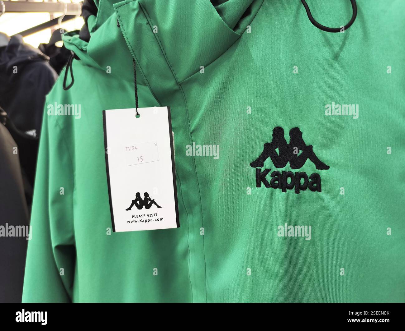 Green kappa jacket with logo and price tag in clothing store display ...