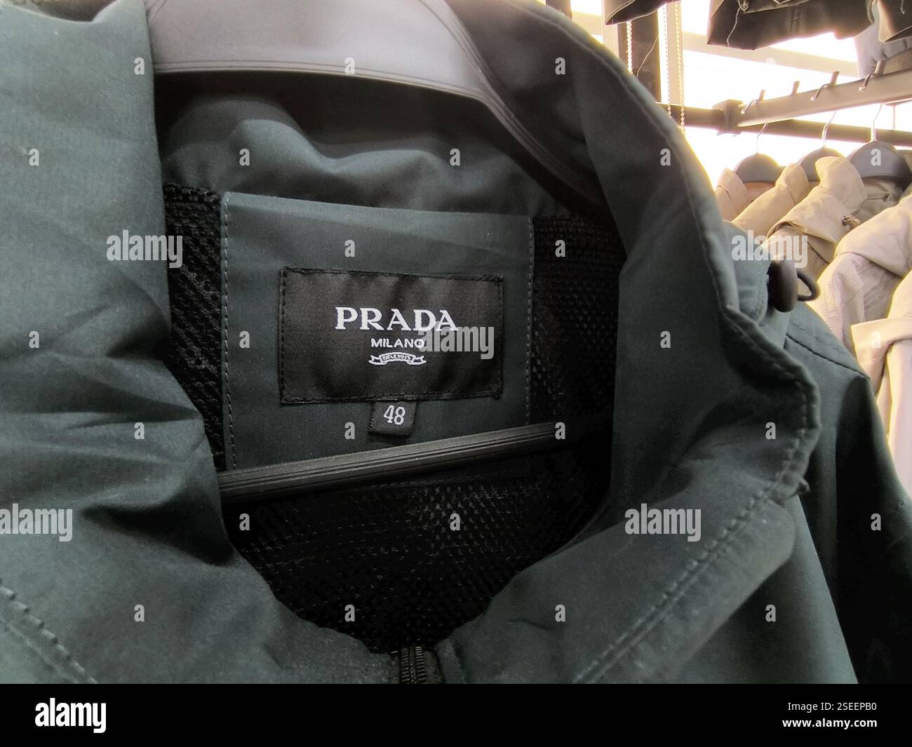 Prada jacket label on dark green outerwear in clothing store display ...