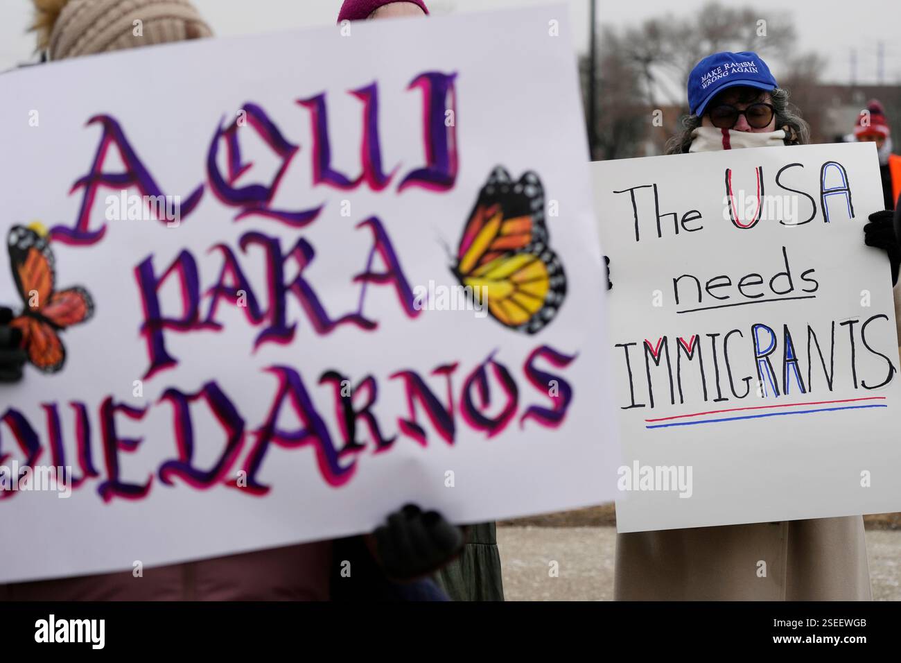 People hold up signs during the Stop The Attacks on Immigrants protest ...