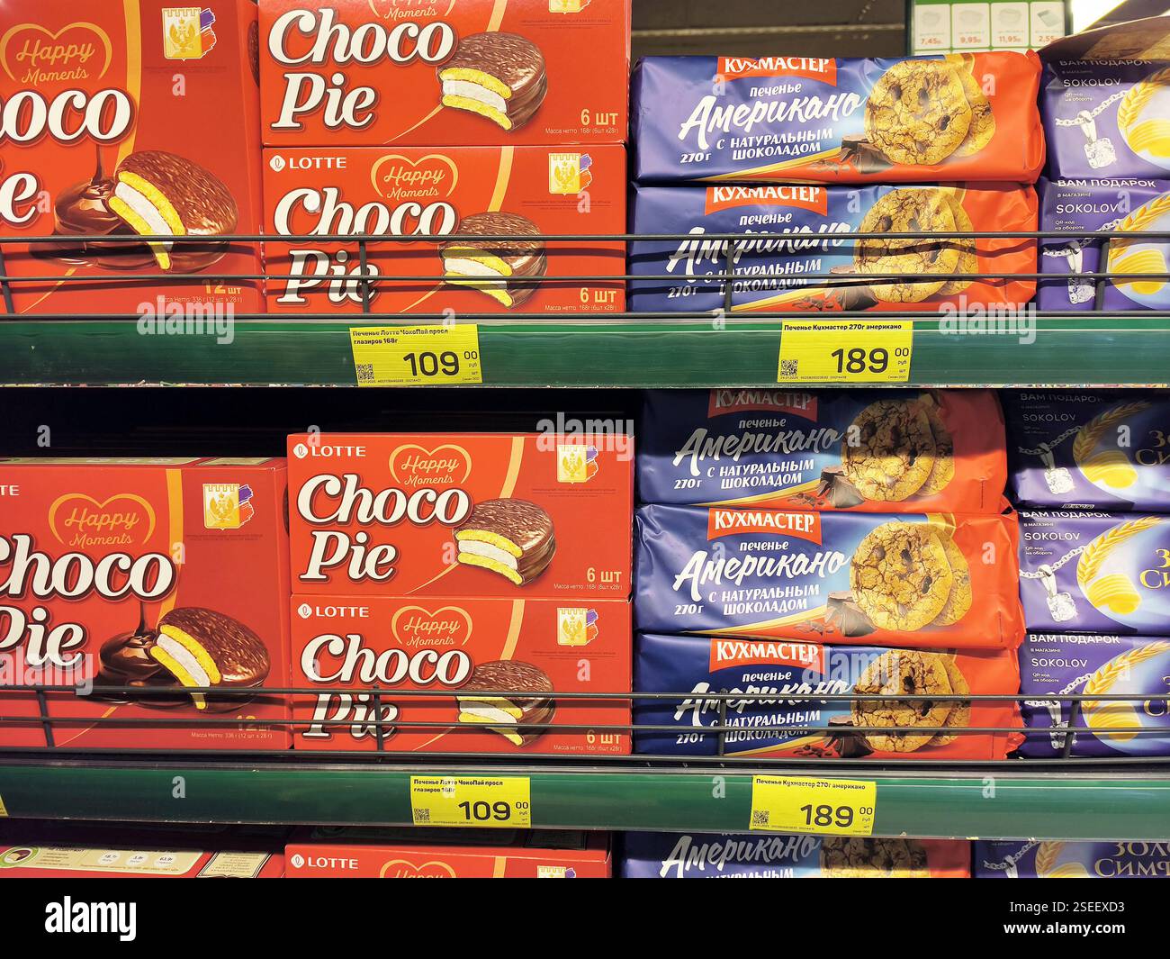 Variety of packaged snacks on supermarket shelves with price tags Stock ...