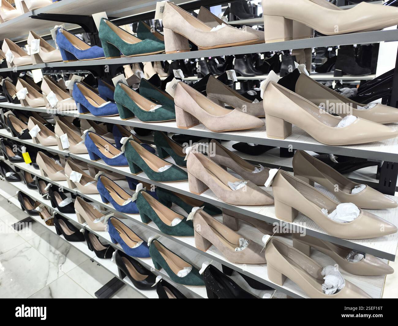 Women's block heel shoes displayed on store shelves in various colors ...