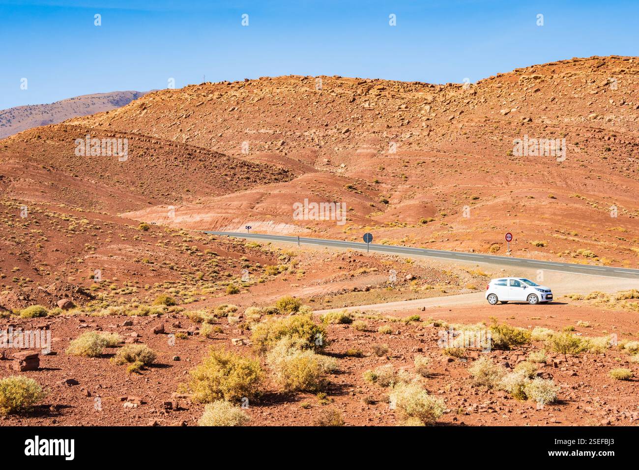Rental car parking near paved asphalt road in Atlas mountains with high ...
