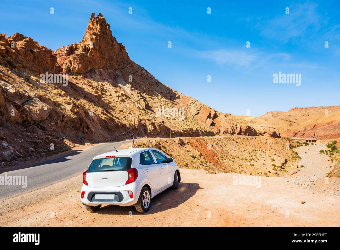 Rental car parking near paved asphalt road in Atlas mountains with high ...