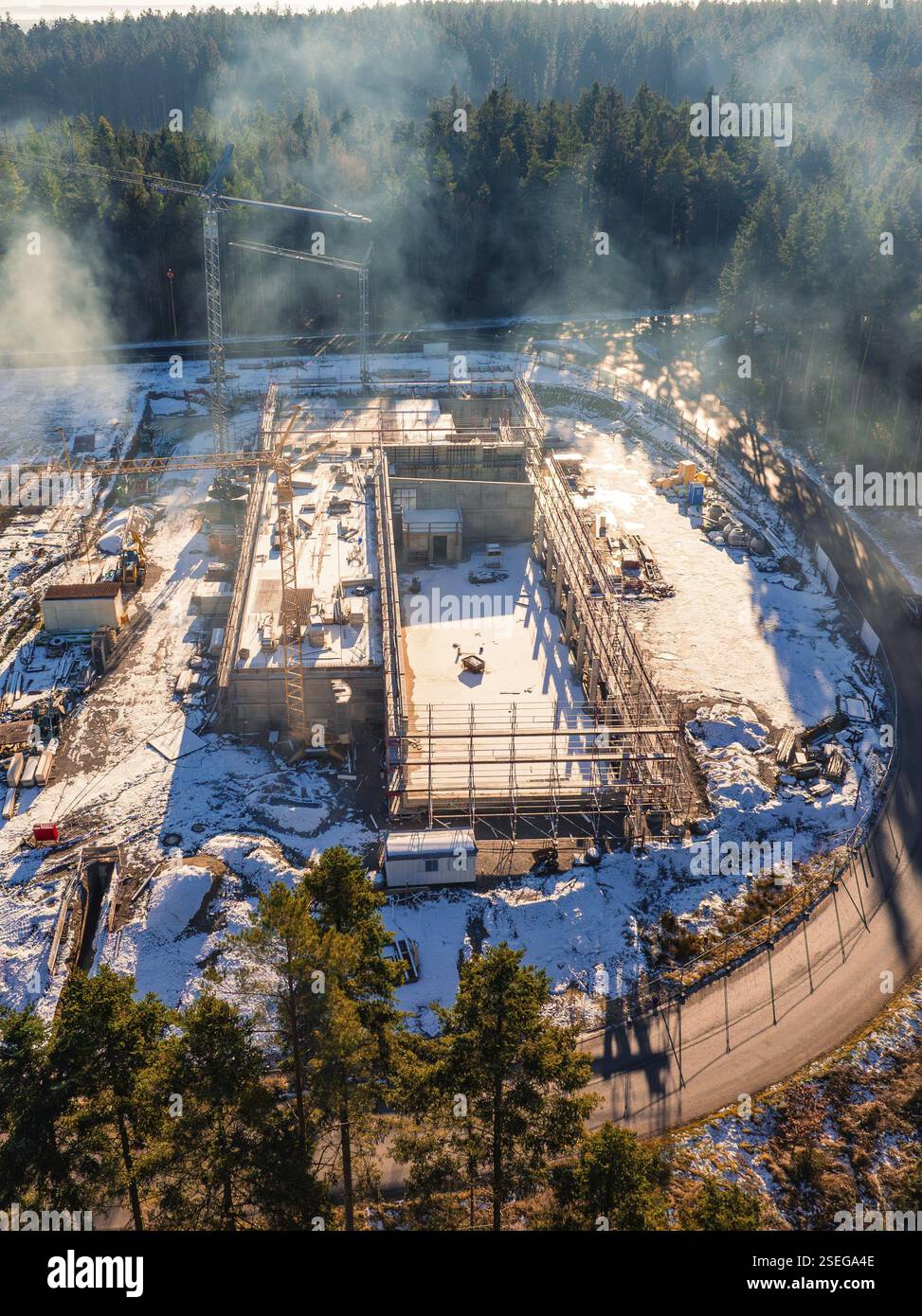 Snow-covered construction site with scaffolding and crane in the wintry ...