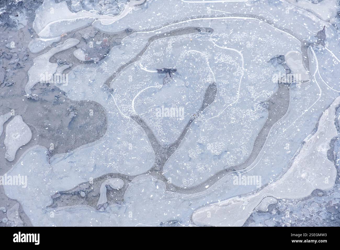 Frozen ice surface with abstract, textured patterns in a wintry setting ...